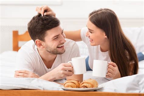 Joyful Couple In Love Having Breakfast In Bed In Bedroom Stock Image