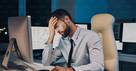 셔츠와 넥타이를 입은 좌절한 청년이 사무실에 늦게까지 머무르는 동안 두통을 앓고 있다 사진 Unsplash의 컴퓨터 이미지