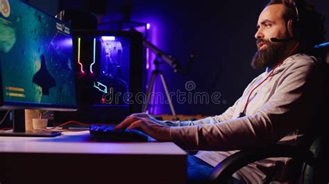 Man In Neon Lit Apartment Playing Singleplayer Videogame With Spaceship Shooting Laser Bullets