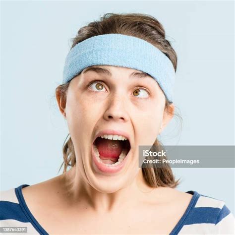 스튜디오에 홀로 서서 머리띠를 쓰고 재미있는 얼굴을 당기는 매력적인 젊은 여성의 샷 25 29세에 대한 스톡 사진 및 기타 이미지 25 29세 30 39세 개성 개념