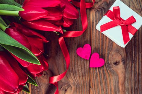 튤립 복사 공간와 소박한 나무 배경에 붉은 활과 마음과 선물 상자 공간이 봄 테두리입니다 여자의 날 어머니의 날 또는 생일 휴일 인사말 카드 개념에 대한 스톡 사진 및 기타