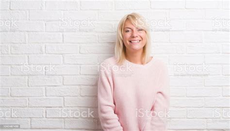 얼굴에는 행복 하 고 멋진 미소와 겨울 스웨터를 입고 흰색 벽돌 벽을 통해 성인 백인 여자 운이 좋은 사람 가을에 대한 스톡 사진 및 기타 이미지 Istock