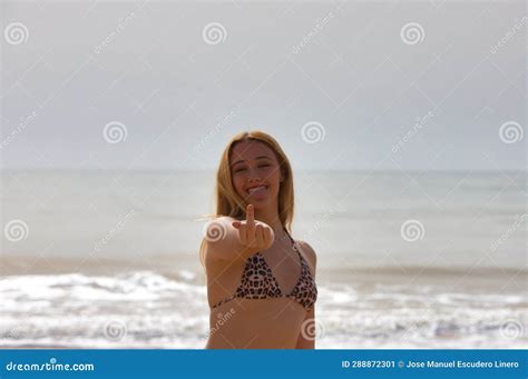 Pretty Young Blonde Woman Raises Her Middle Finger To Show