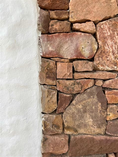 흰색 석고 대비가 있는 소박한 벽돌 벽 · 무료 스톡 사진