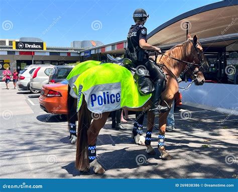 Australian Mounted Policewoman Sitting On A Police Horse In A Parking