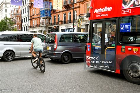 자동차와 버스 사이의 도로 교차로를 횡단하는 자전거 타는 사람 거리에 대한 스톡 사진 및 기타 이미지 거리 교통 교통 체증 Istock
