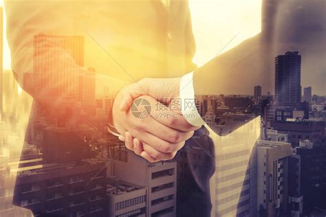 商业界人士与城市风景背握手的双重接触交易成功伙伴关系团队精神概高清图片下载 正版图片503732329 摄图网