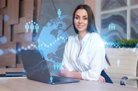 사무실 배경 위에 Hr 소셜 미디어 홀로그램 아이콘을 컨설팅하는 국제 비즈니스 컨설팅을 위해 새 직원을 고용하기 위해 노트북으로 작업하는 직장에서 흰 셔츠를 입은 매력적인