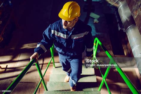 파란색 작업복을 입고 계단을 오르는 머리에 보호 헬멧을 착용한 백인 노동자의 전체 길이 에너지 공장 인테리어 계단에 대한 스톡 사진 및 기타 이미지 Istock