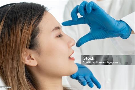 성형 수술 미용 외과 의사 또는 미용사가 여성의 얼굴을 만지고 코 모양을 바꾸는 수술 코 성형술 전에 환자의 코를 검사하는 의사 의료 지원 건강 사람 얼굴에 대한 스톡 사진