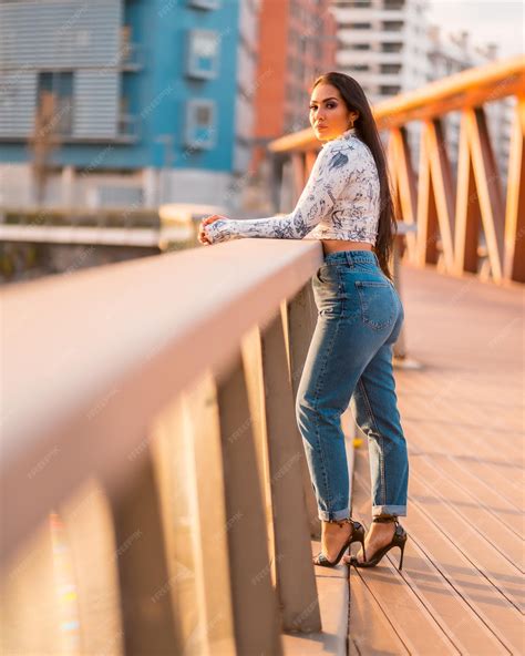 Premium Photo A Brunette Latin Girl In Jeans In The City At Sunset On