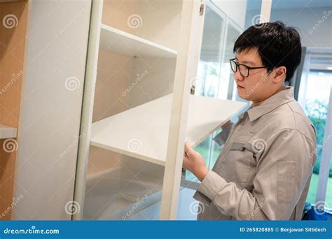 Asian Male Furniture Assembler Installing Cabinet Panel Stock Image