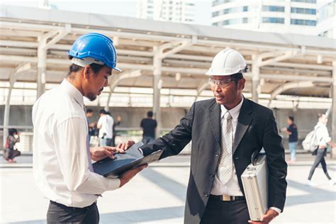 토목 엔지니어 팀이 함께 협력하여 현대 도시의 건설 현장에서 작업자 헬멧 하드햇을 착용합니다 포먼 산업 프로젝트 매니저 엔지니어 팀워크 아시아 산업 프로 팀 25 29세에