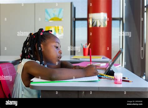 Focused African American Schoolgirl Having Tablet Video Call In