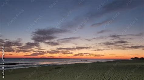 Wideo Stock 강원도 서핑 비치 낙산 해수욕장 파도치는 바다에 해뜨기 전 하늘이 붉게 물들고 있는 Adobe Stock