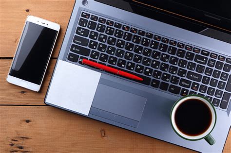 노트북과 한 잔의 커피는 오래 된 책상 스마트폰 키보드 펜 나무 배경에 복사 공간 미니 관리자의 직장에서 커피의 스타일에 디자이너 워크스테이션 개념에 대한 스톡 사진 및