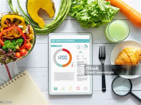 칼로리 계산 다이어트 음식 제어 및 체중 감소 개념 샐러드 과일 주스 빵과 야채와 식탁에서 화면에 칼로리 카운터 응용 프로그램과 태블릿 건강한 식생활에 대한 스톡 사진 및
