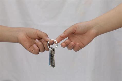 Premium Photo Hands Of Woman Giving Keys To A Man On White Background