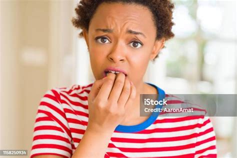 젊은 아름 다운 아프리카 계 미국인 여자 집에서 보고 스트레스와 긴장 으로 손 에 입 물고 손톱 불안 문제 T 셔츠에 대한 스톡 사진 및 기타 이미지 Istock