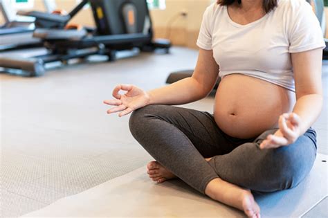 요가룸의 피트니스 센터에서 활동적인 임산부 운동을 합니다 임신 한 배에 아기를 들고 젊은 기대 어머니 출산 전 관리 및 여성 임신 개념 건강한 생활방식에 대한 스톡 사진 및
