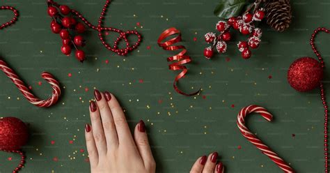 크리스마스 매니큐어 빨간 손톱 녹색 배경에 체크무늬 셔츠를 입은 손 빨간 크리스마스 싸구려를 프레임으로 사용합니다 사진 Unsplash의 빨강 이미지