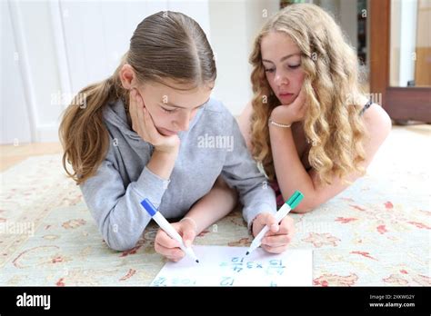 Two Girls Doing Maths Math Lying On Floor Writing On Whiteboard With Pens Fractions Mathematics Two Girls Doing Maths Math Lying On Floor Writing On Whiteboard With Pens Fractions Mathematics