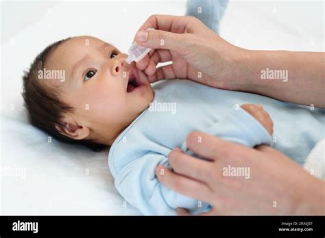 Newborn Baby Gets Nose Drops By Mother On A Bed Stock Photo Alamy