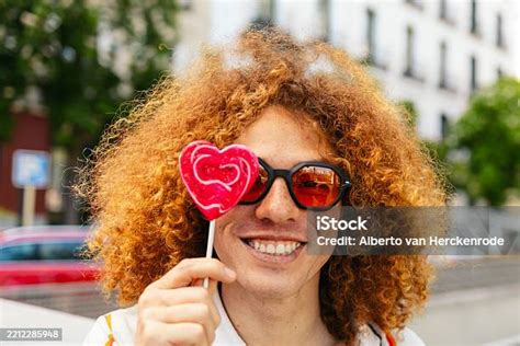 생강 Lgbtqia 플러스 활동가가 하트 모양의 막대 사탕을 들고 프라이드의 달을 축하합니다 Lgbt 프라이드의 달에 대한 스톡