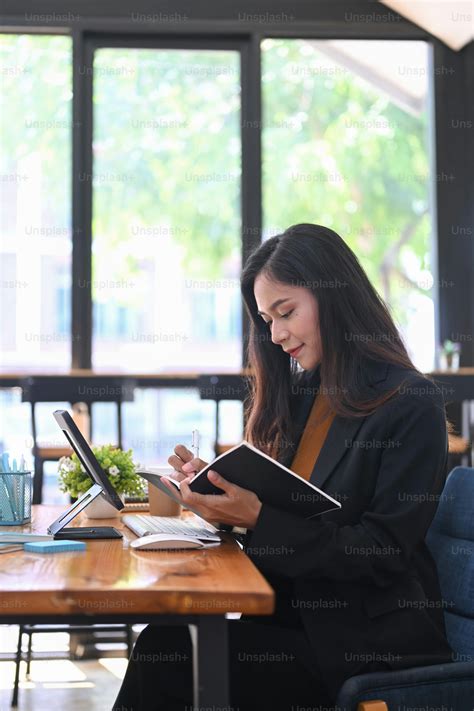 현대 직장에 앉아 노트북에 메모를 하는 성공적인 사업가의 측면 모습 사진 Unsplash의 태국 이미지