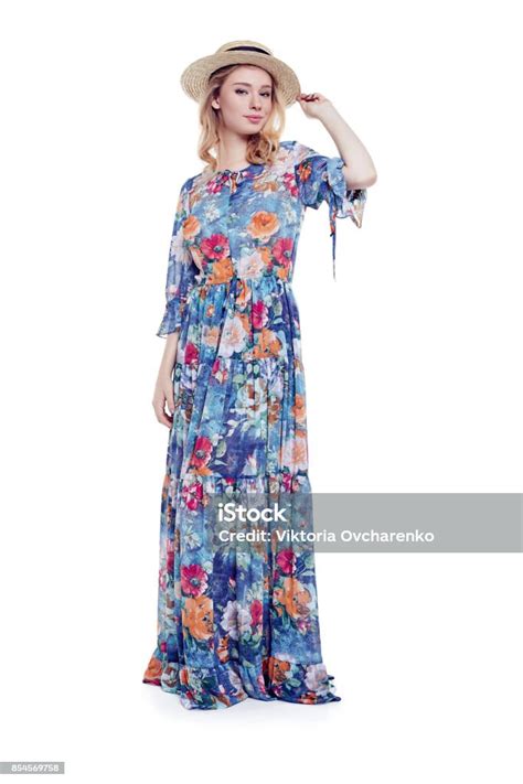 밀 짚 모자에 긴 다채로운 꽃 드레스 패션 모델 소녀 전체 길이 초상화 흰색 배경에 고립 캐주얼 여름 거리와 해변 스타일입니다