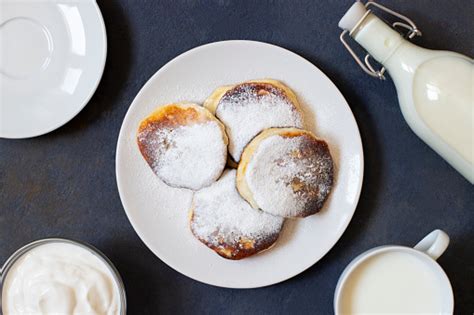 코 티 지 치즈 팬케이크 치즈 케이크 이 건강 한 아침 식사 화이트 요리 우유 병 우유 한 잔 요구르트 또는 사 워 크림 어두운 배경입니다 평면도 텍스트 공간 0명에 대한
