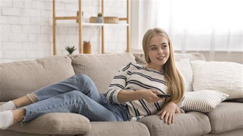 Niña Brisa Sentada En El Sofá En Casa Viendo La Televisión Foto De