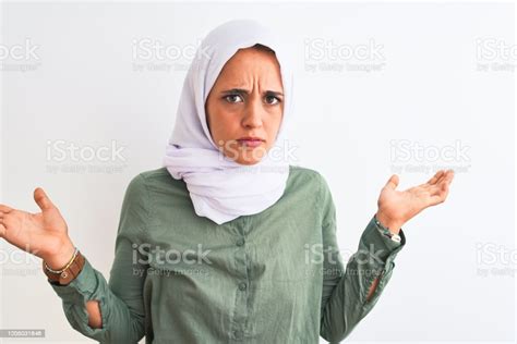 고립 된 배경 에 전통적인 이슬람 히잡을 입고 젊은 아름다운 아랍 여성은 팔과 손을 들고 단서와 혼란 표정을 의심 개념 아랍문화에 대한 스톡 사진 및 기타 이미지 Istock