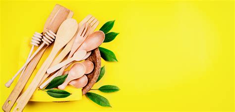 노란색 배경에 눌린 종이 접시에 일회용 수저 대나무 나무와 종이 드랩 숟가락 포크 나이프 대나무 그릇 등으로 만든 환경 친화적 인 일회용 도구 공간을 복사합니다 0명에 대한