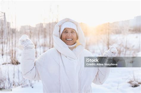 화창한 겨울 야외에서 눈과 놀고 흰색 따뜻한 아웃웨어에 행복한 노인 성숙한 여성 은퇴 한 건강한 사람들 휴가 겨울 활동 활동적인 라이프 스타일 컨셉 60 69세에 대한 스톡