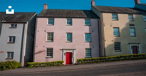 빨간 문이 있는 파스텔 색상의 집들이 줄지어 서 있습니다 사진 Unsplash의 무료 펜린 이미지