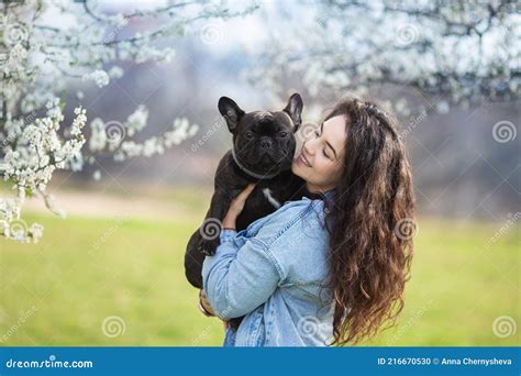 красивая молодая женщина играет с бульдогом на улице милая хипстерская девушка обнимает и