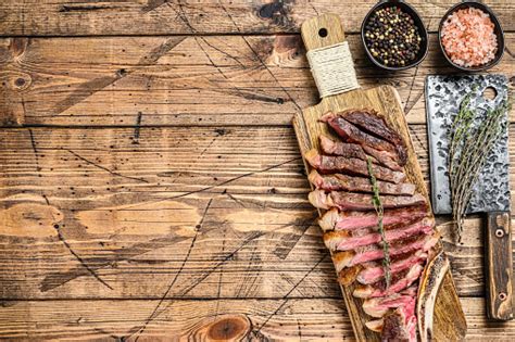 허브와 향신료를 곁들인 구운 카우보이 또는 리비아이 소고기 스테이크 나무 배경 맨 위 보기입니다 복사 공간 갈비 스테이크에 대한