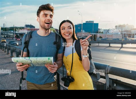 Handsome Man Holding Map And Asian Woman Pointing With Finger Stock Photo Alamy