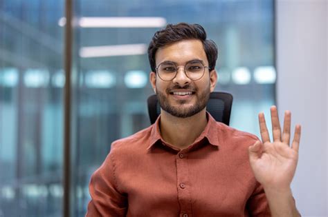 현대적인 사무실 환경에서 손을 흔들고 미소를 지으며 기업 및 전문 환경에 이상적인 친근하고 친근한 태도를 보여주는 자신감 넘치는