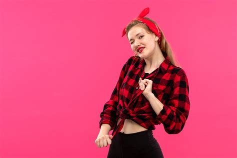 Вид спереди молодой привлекательной дамы в клетчатой красно черной рубашке черных брюк