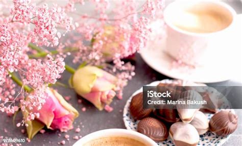 아침에 분홍색 꽃의 꽃다발 향기로운 커피 한잔 Cockleshells의 형태로 초콜릿 과자입니다 컵에 포탄입니다 낭만 밝은 색상입니다 안녕하세요 카드 개념에 대한 스톡 사진