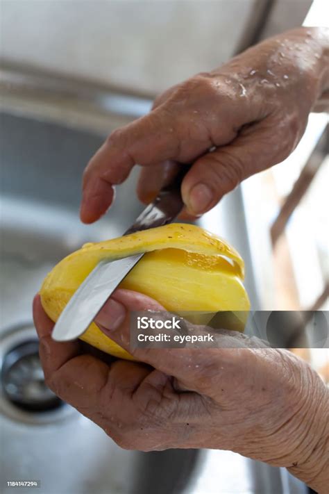 싱크대 배경에서 달콤한 노란색 망고를 벗겨 칼을 사용하는 시니어 여성의 오른손 클로즈업 샷 선택적 초점 태국 전통 과일 가정 주방에 대한 스톡 사진 및 기타 이미지 Istock