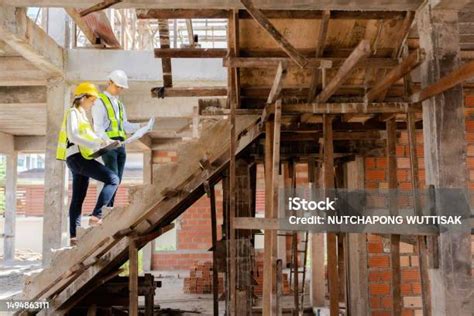 두 명의 아시아계 남녀 엔지니어가 청사진과 목록 노트를 보고 있다 건축에 관한 건설 작업의 설계에서 계단을 걷다 미래 산업의