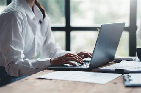 비즈니스 여성의 손을 클로즈업하여 랩톱 컴퓨터에 주의 깊게 타이핑하고 사무실 책상 위에 문서를 올려놓는 모습 공부에 대한 스톡 사진 및 기타 이미지 Istock