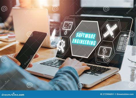 Person Working On Laptop Computer On Desk With Software Engineering Icon On Virtual Screen Stock