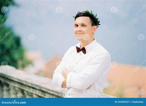 Groom In A Green Wreath Stands With His Arms Crossed On His Chest In The Garden Stock Image