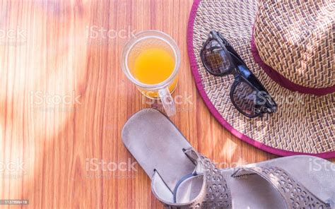 여행할 준비가 되었습니다 나무 테이블에 필수적인 현대 여름 여성 액세서리의 상위 뷰 해변 배경 선글라스 밀 짚 모자 플립 플롭 라임 주스 한 잔 왼쪽에 텍스트에 대 한 공간
