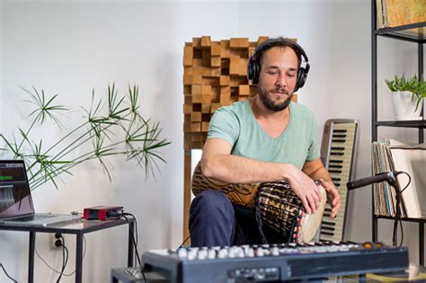 집에서 디지털 스튜디오에서 젬 베 드럼 악기를 녹음 전문 음악가 그는 악기와 Midi 컨트롤러로 둘러싸여 있습니다 음악 제작