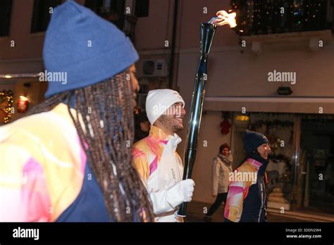 A Torchbearer Carries The Olympic Flame During The Torch Relay To The